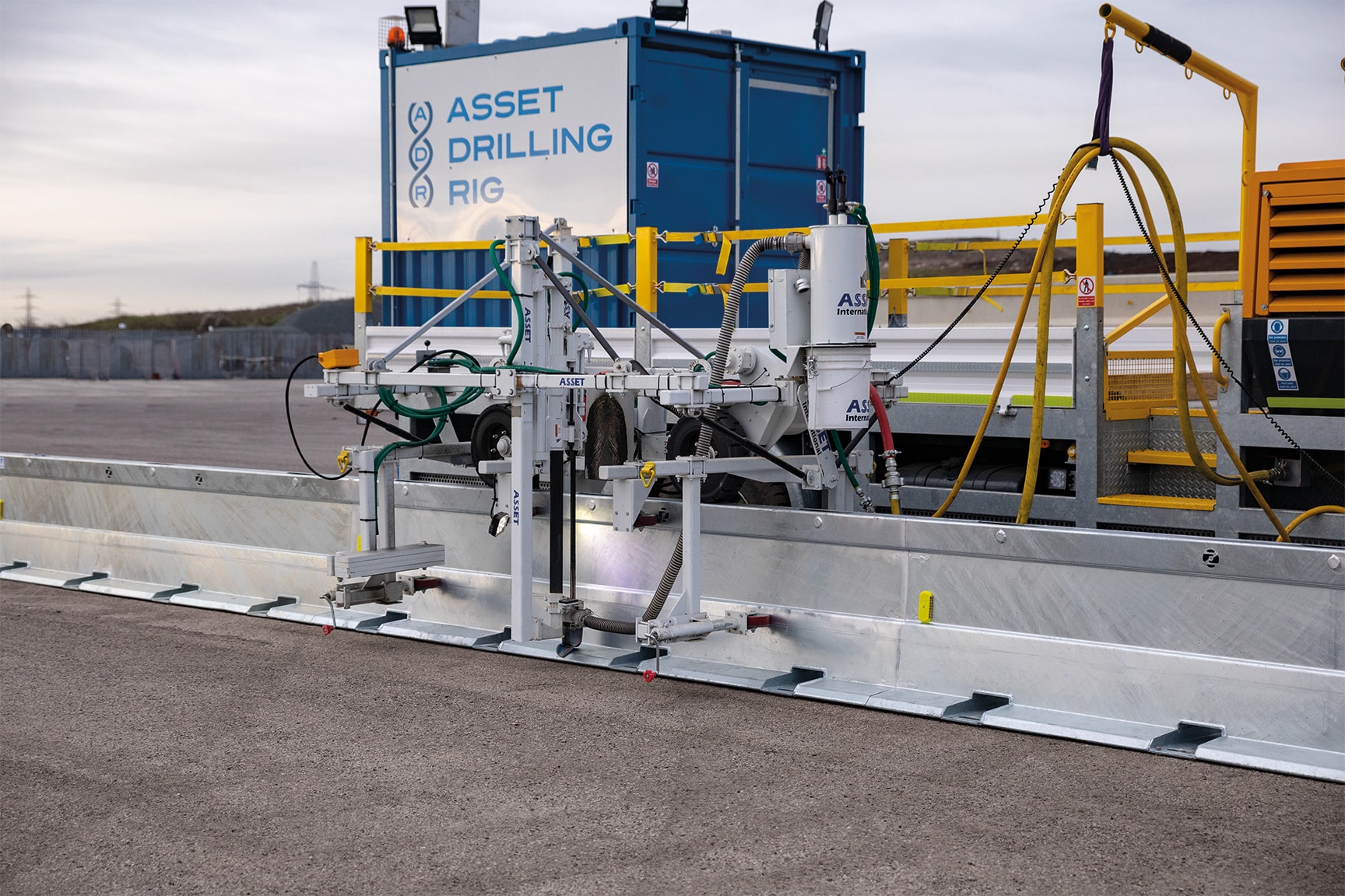 Asset drilling rig for highway barrier installations